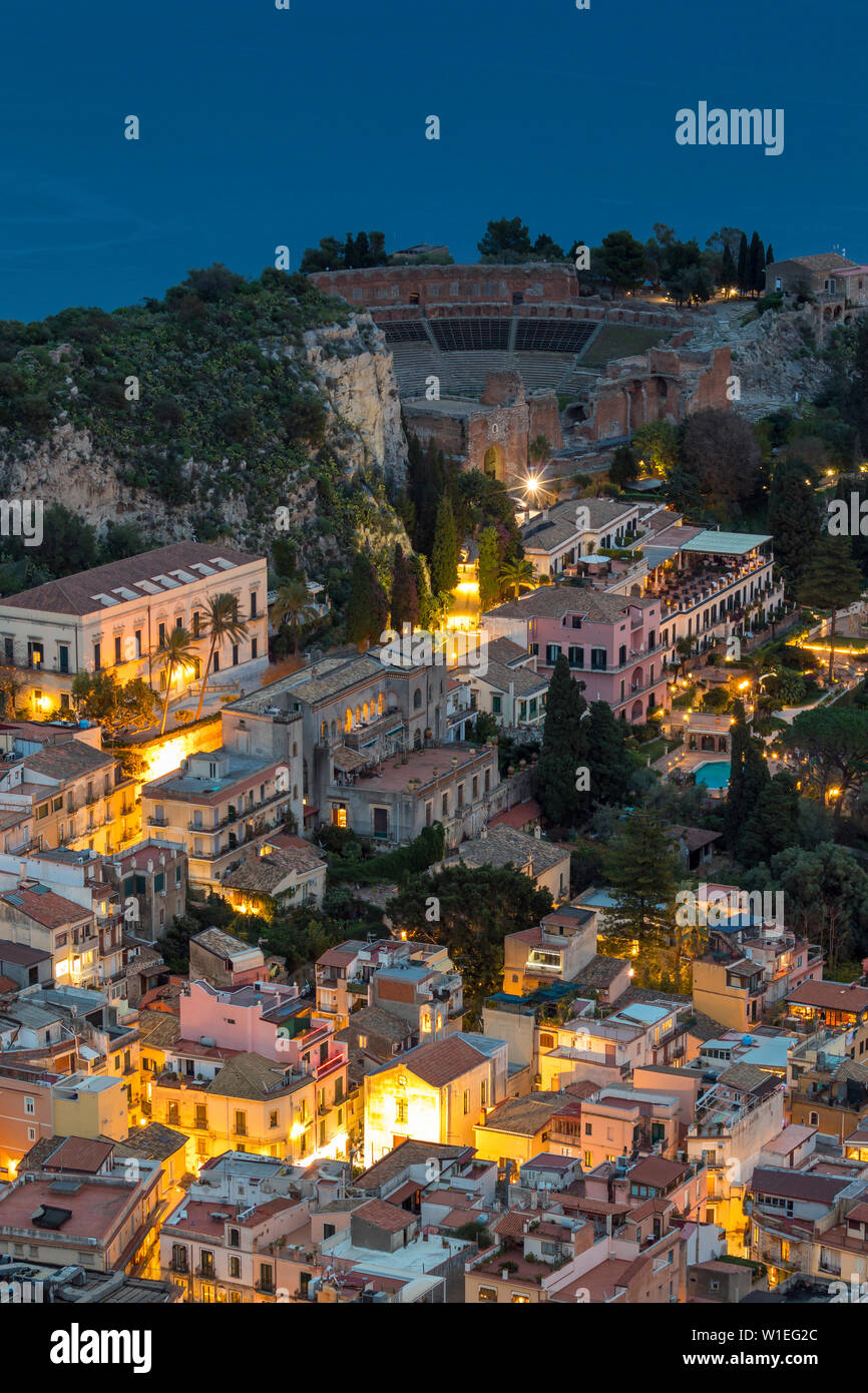 View down to the city centre and the ancient Greek Theatre at dusk ...