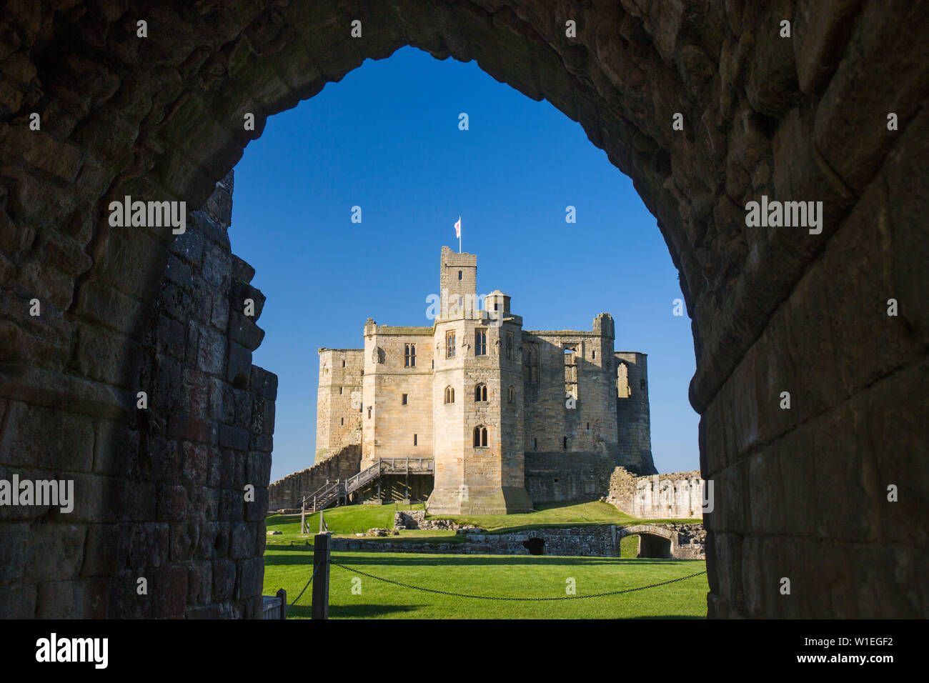 View through arch across lawns to the Great Tower of Warkworth Castle ...