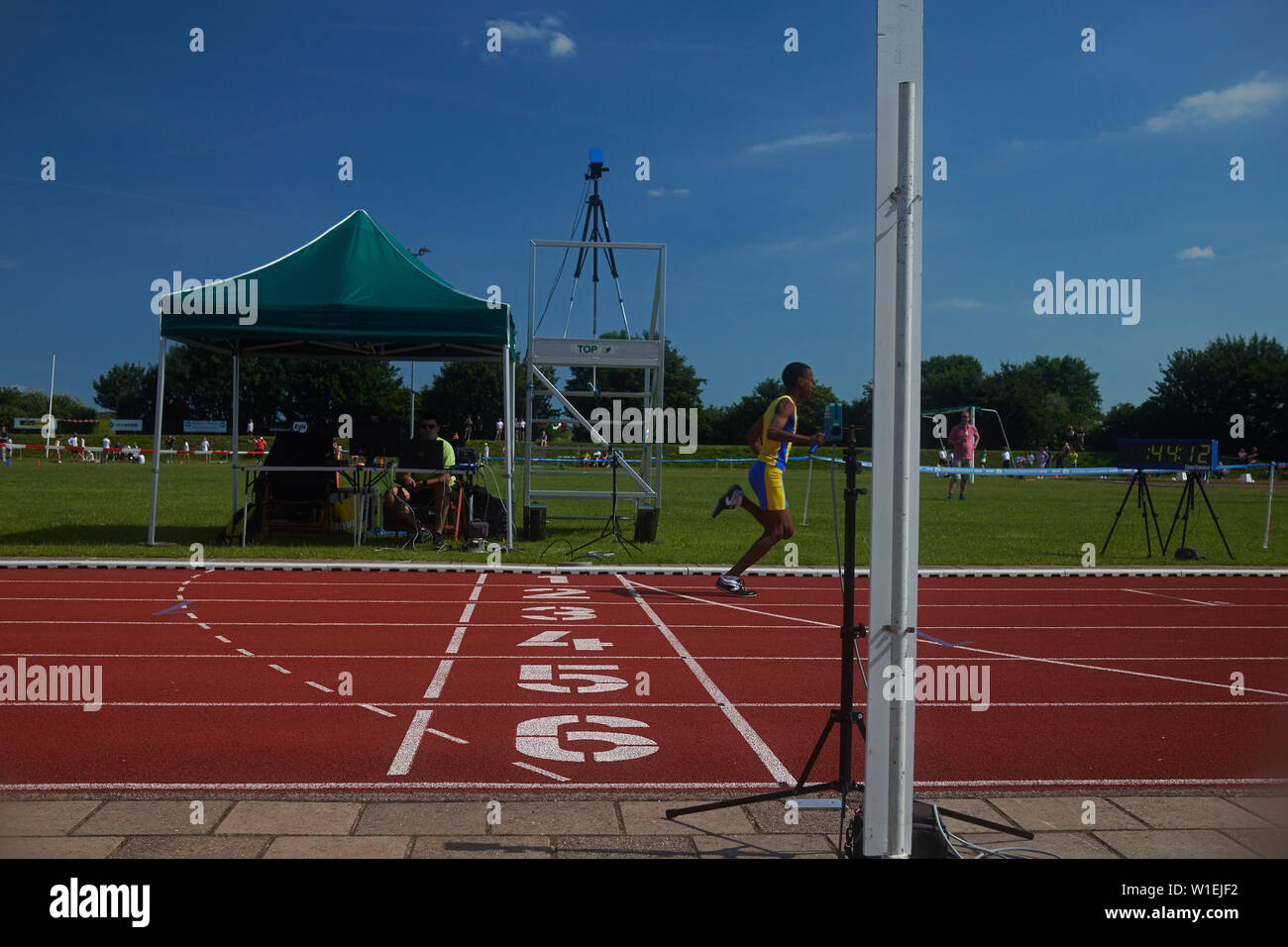Black boy running across the finish line in first position at an ...