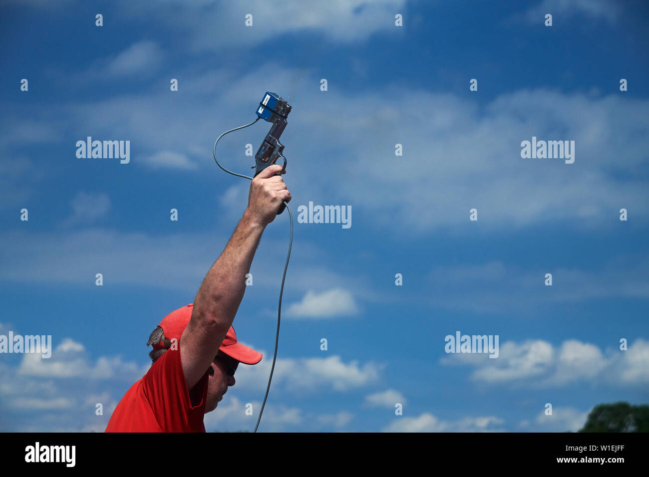 Starter with an electronic gun starting a race at an athletics track in ...