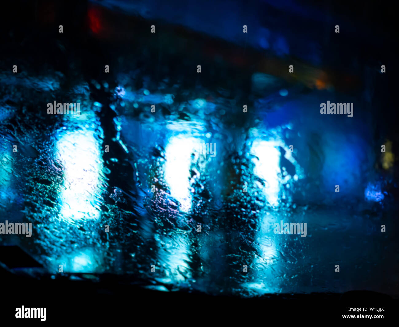Rain drops on car window with road light bokeh on rainy season abstract ...