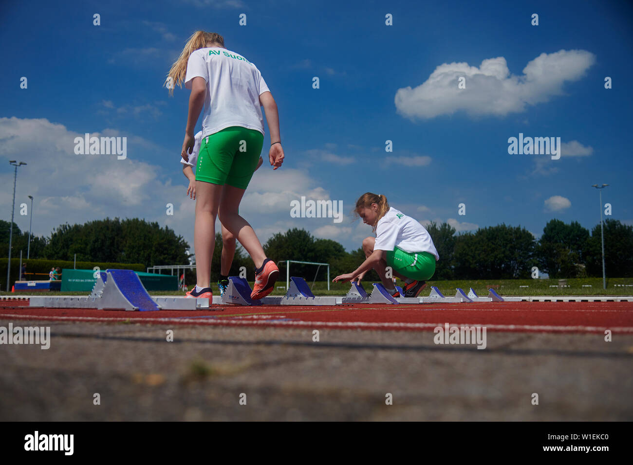 Girls preparing themselves at the starting blocks at an athletics track ...
