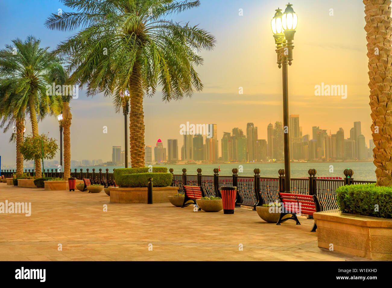 Benches and palm trees along marina walkway in Porto Arabia at the ...