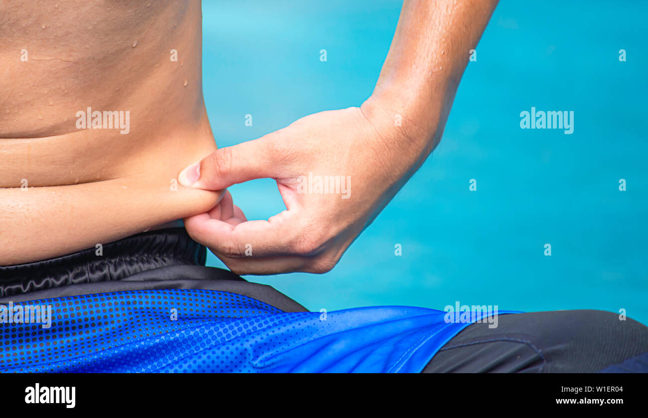 Hand man grip skin excess fat waist Stock Photo - Alamy