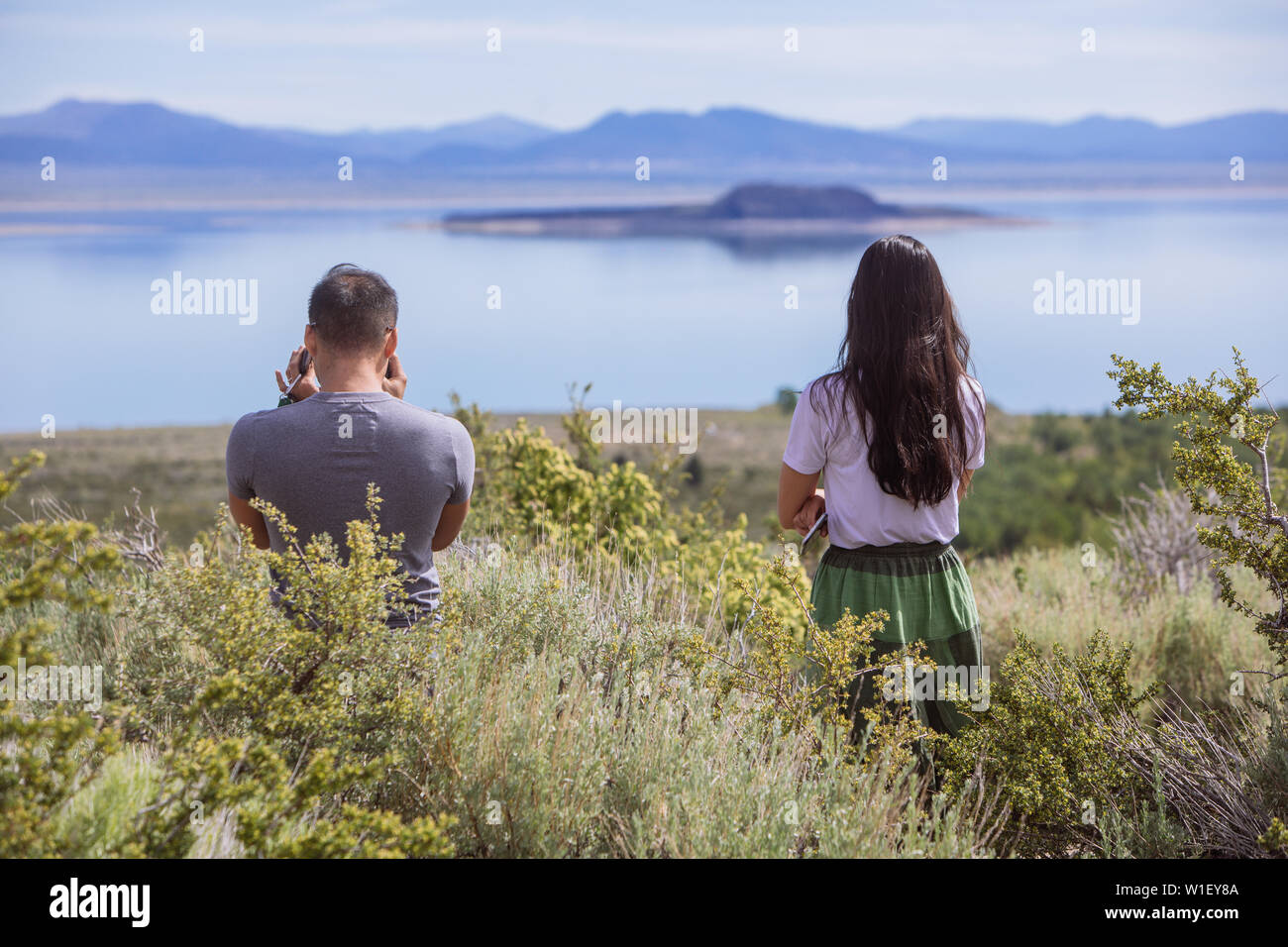 Couple from behind looking towards Paoha Island in Mono Lake Park ...