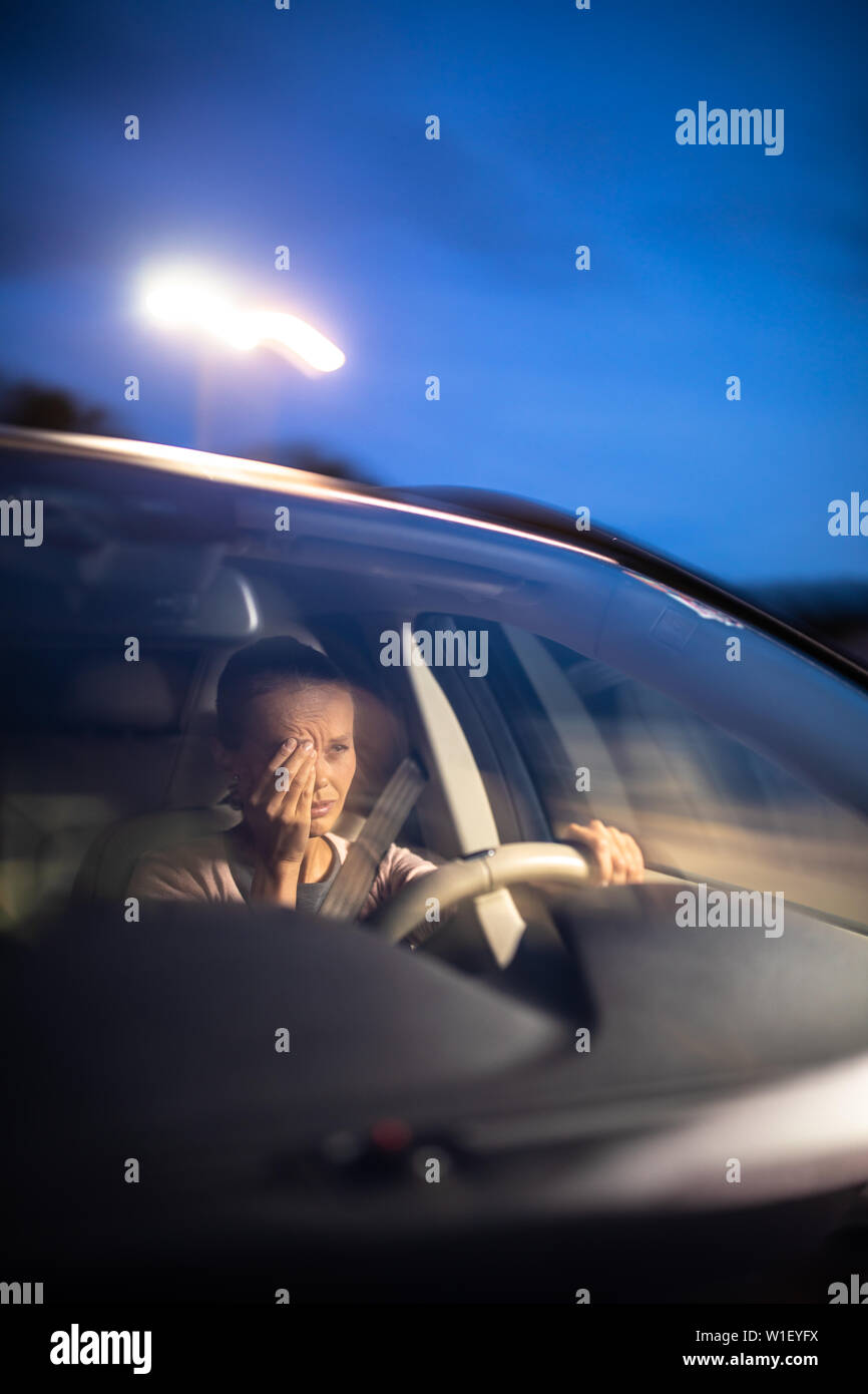 Young female driver at the wheel of her car, super tired, falling ...