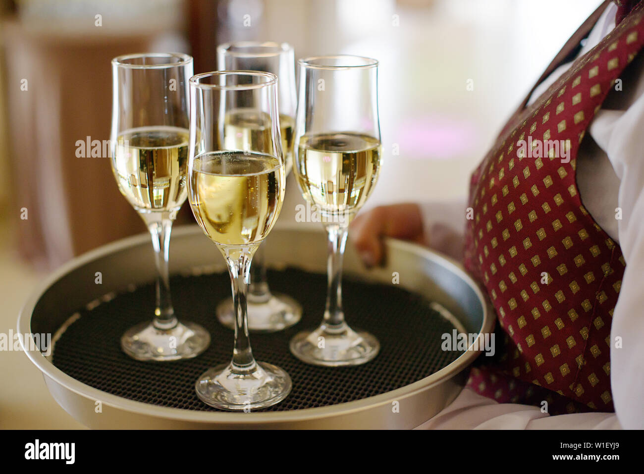 Welcome toast drinks offered by female waiter holding tray of four ...