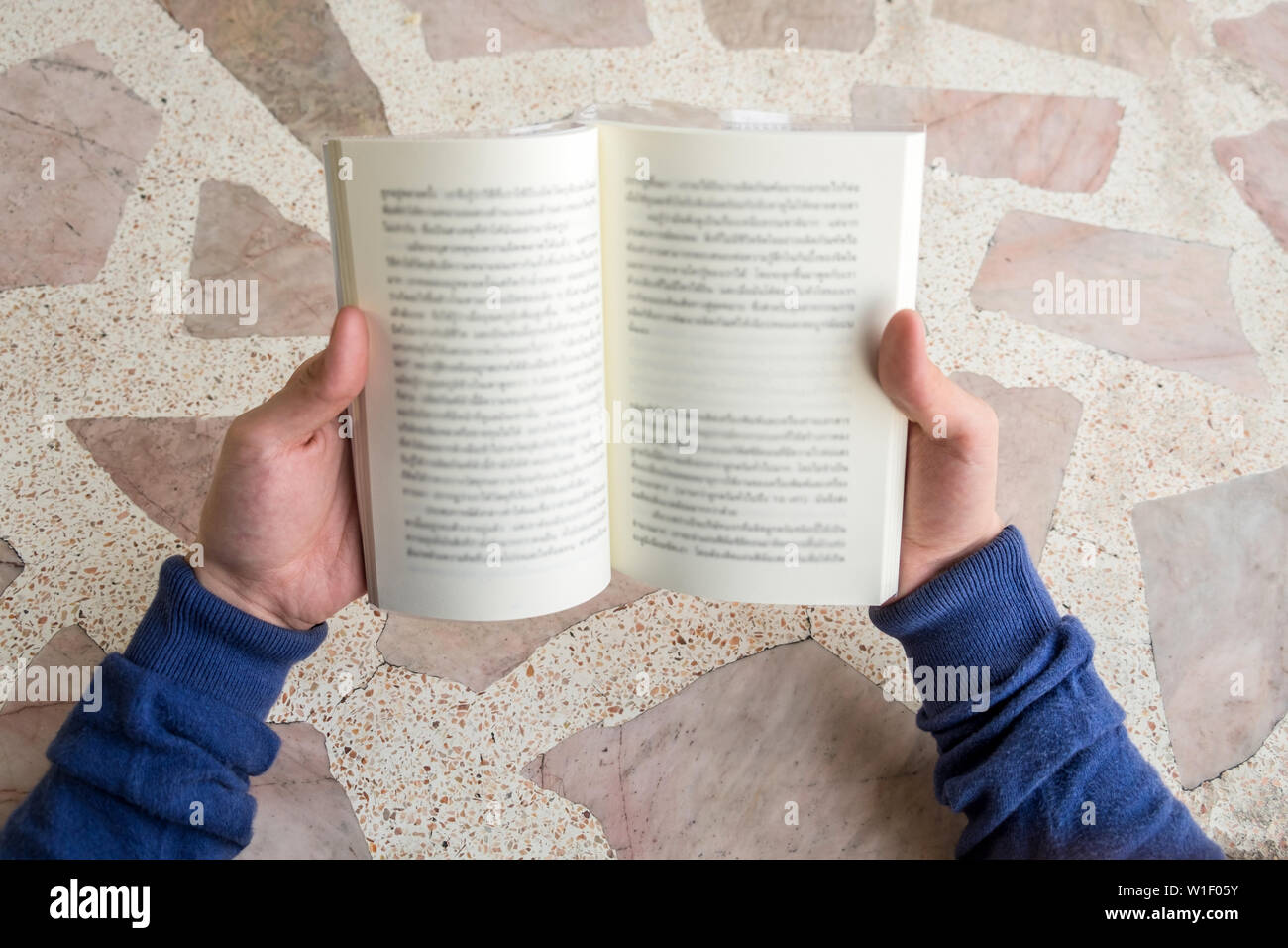 Men open holding reading book on table Stock Photo - Alamy