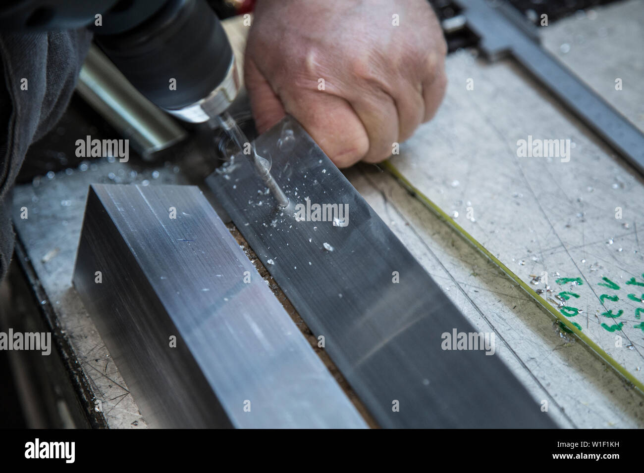 worker drilling whole into rectangular metal pipe Stock Photo - Alamy