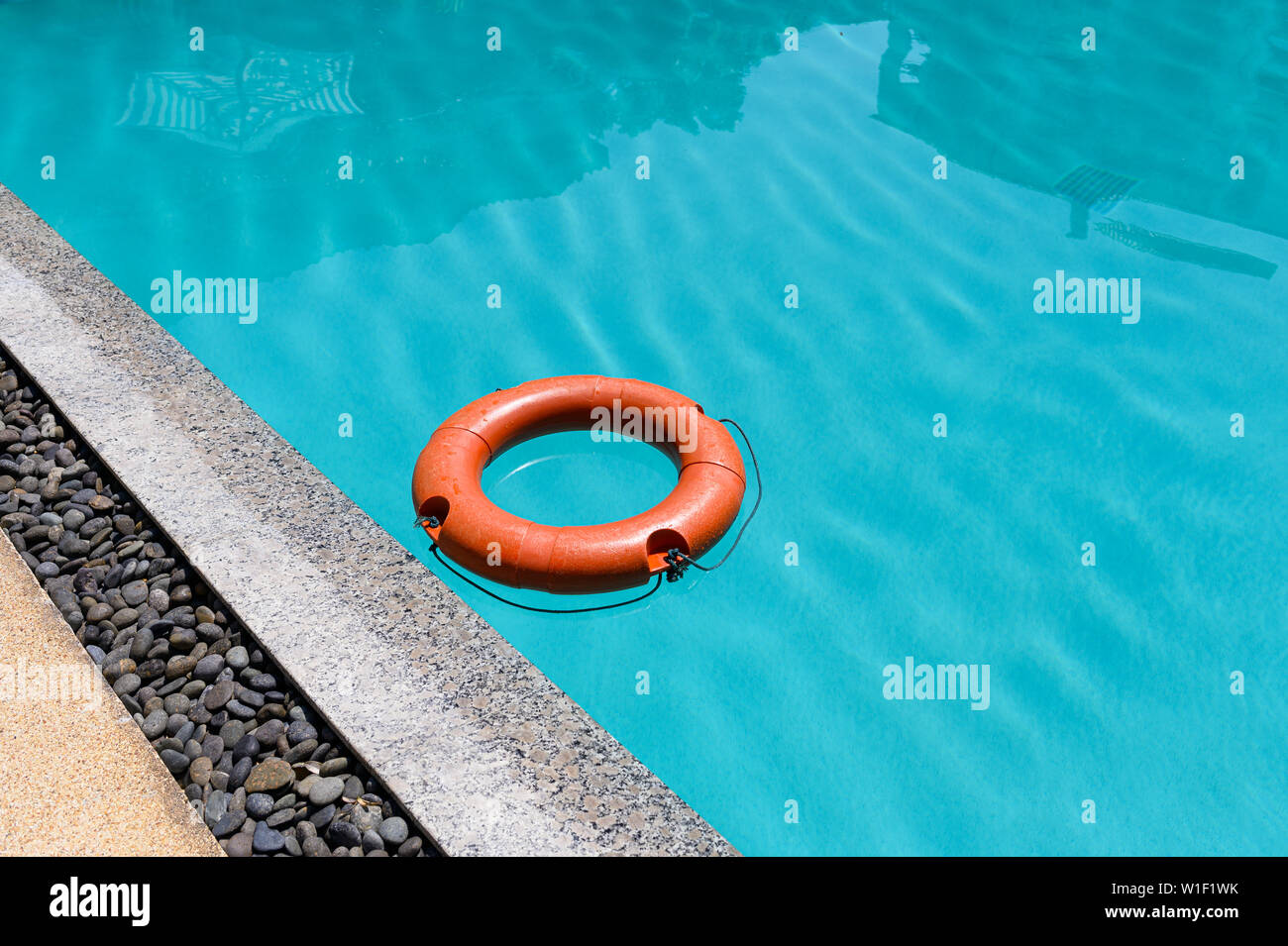 Orange lifebuoy floating on turquoise surface swimming pool Stock Photo ...