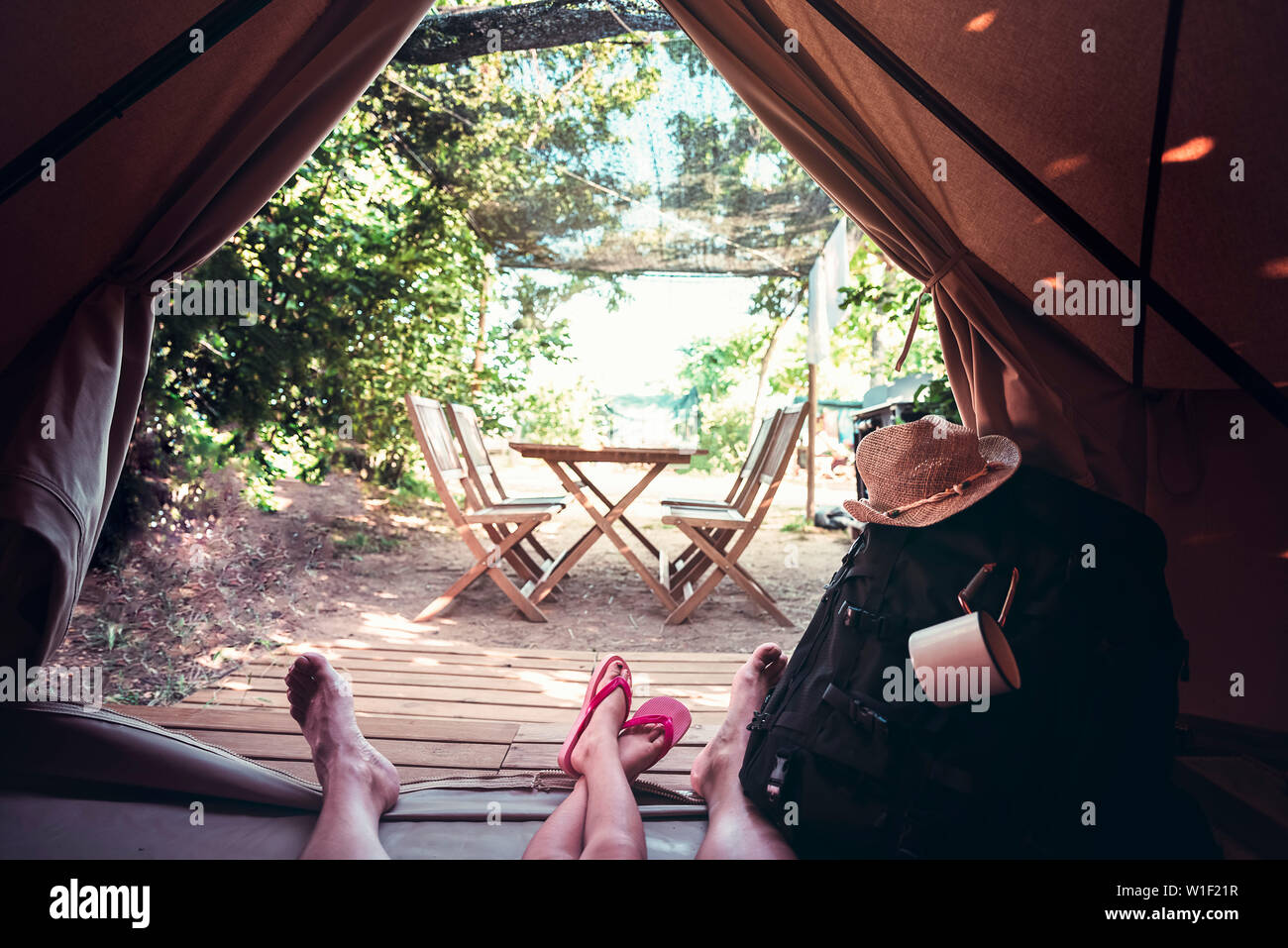 view of the legs of a hiker man with a kid resting barefoot in a ...