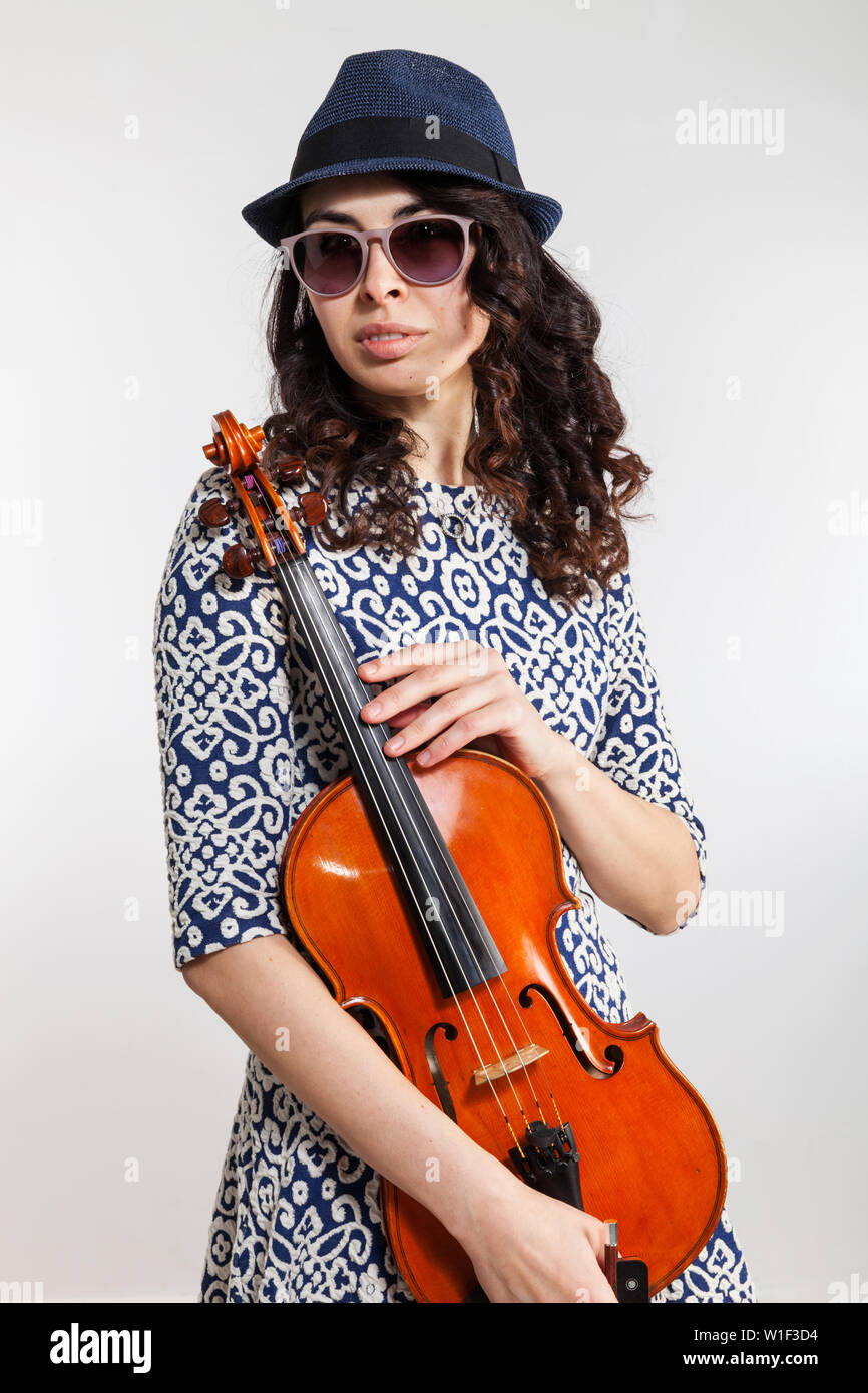 Young beautiful musician posing in studio on white background with ...