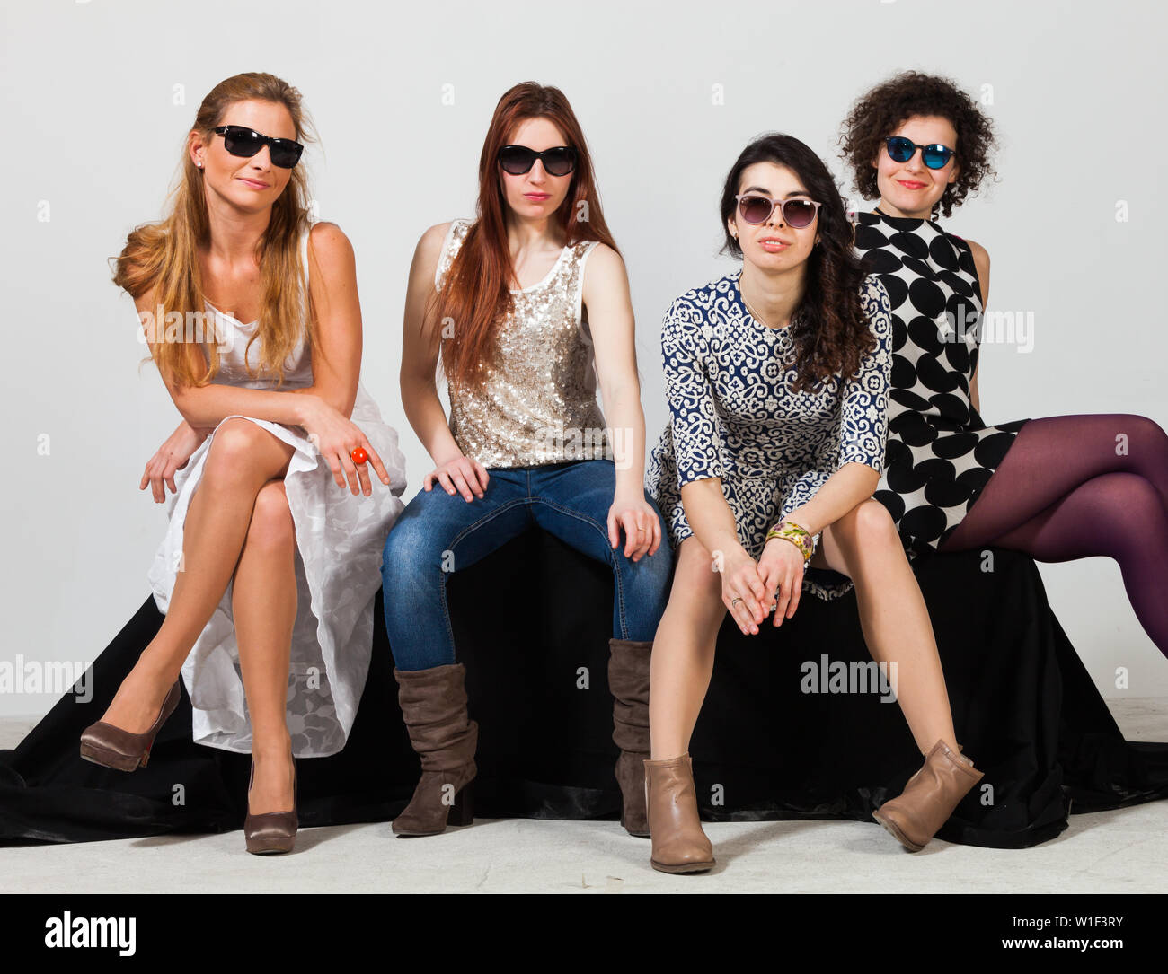 Four beautiful women pose together in the studio Stock Photo - Alamy