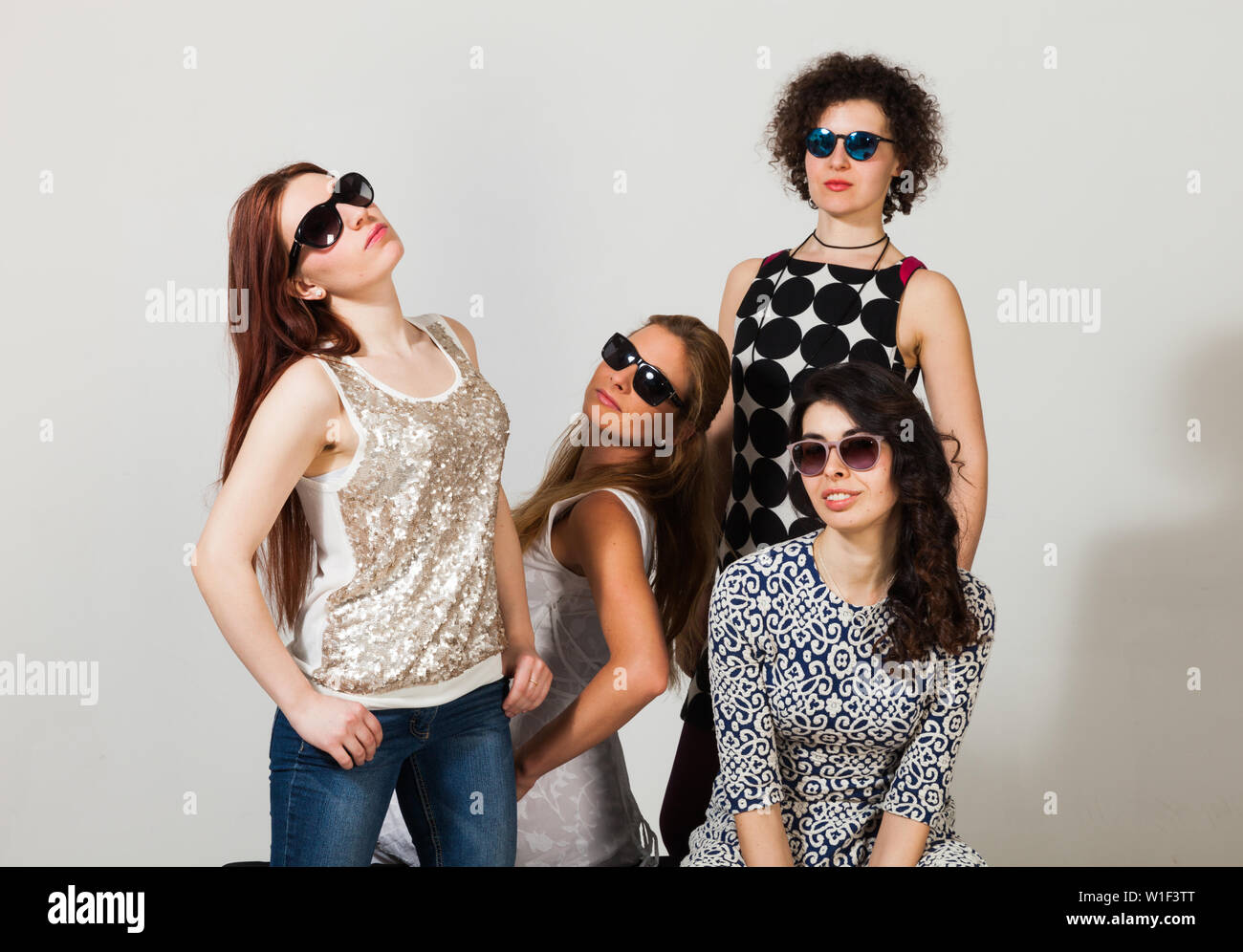 Four beautiful women pose together in the studio Stock Photo - Alamy