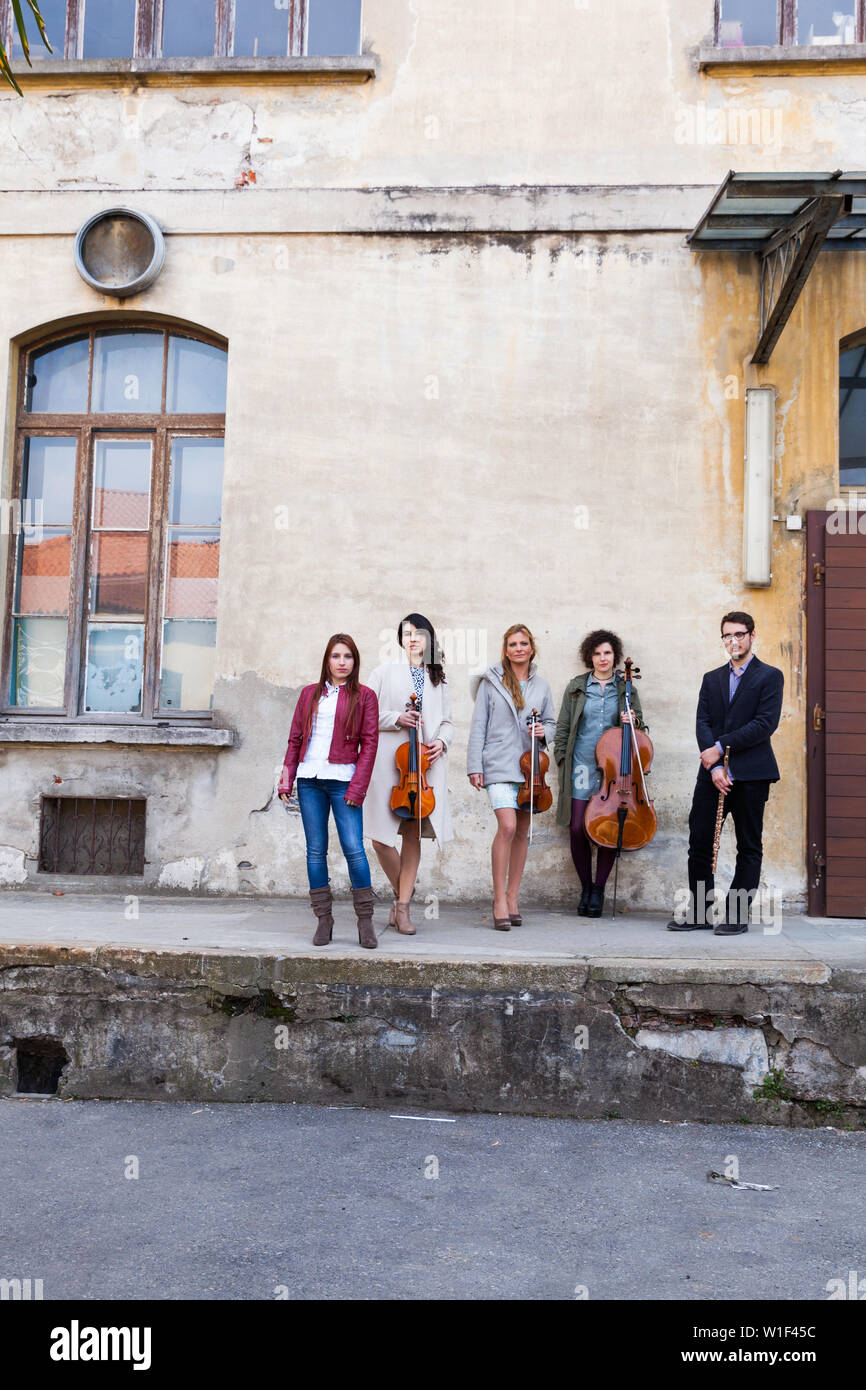 Musical band posing in front of an exterior wall Stock Photo - Alamy