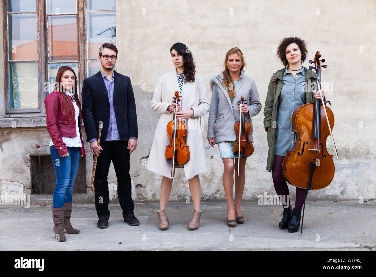 Musical band posing in front of an exterior wall Stock Photo - Alamy