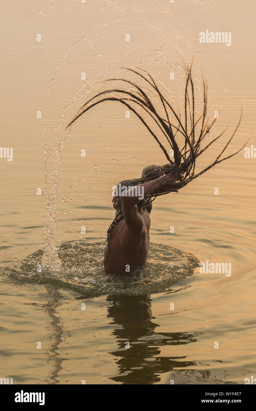 Rome baba with water spraying from his flying dreadlocks in the Ganges ...