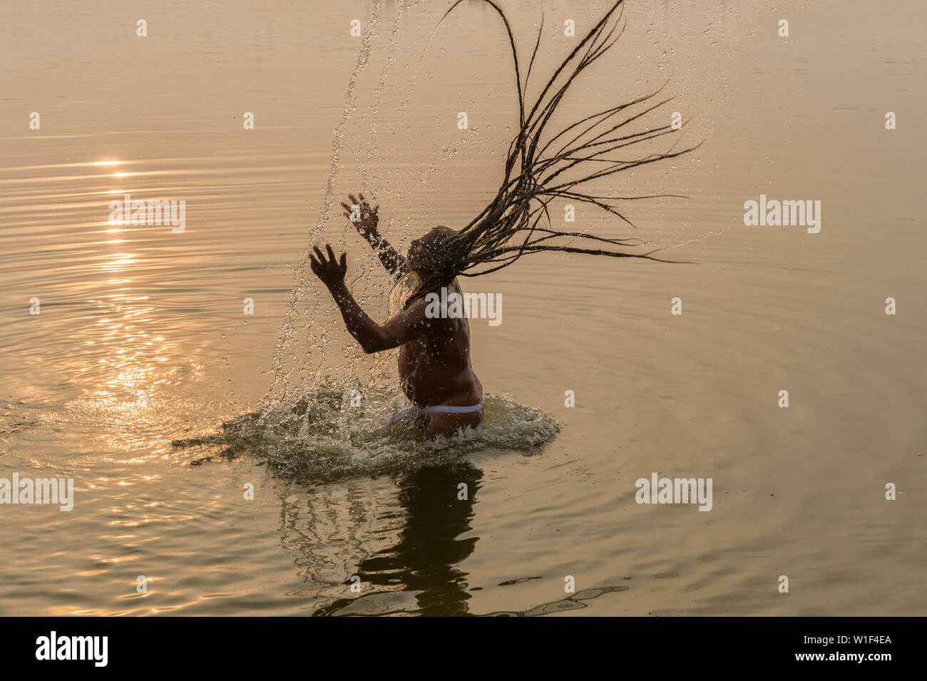 Rome baba with water spraying from his flying dreadlocks in the Ganges ...
