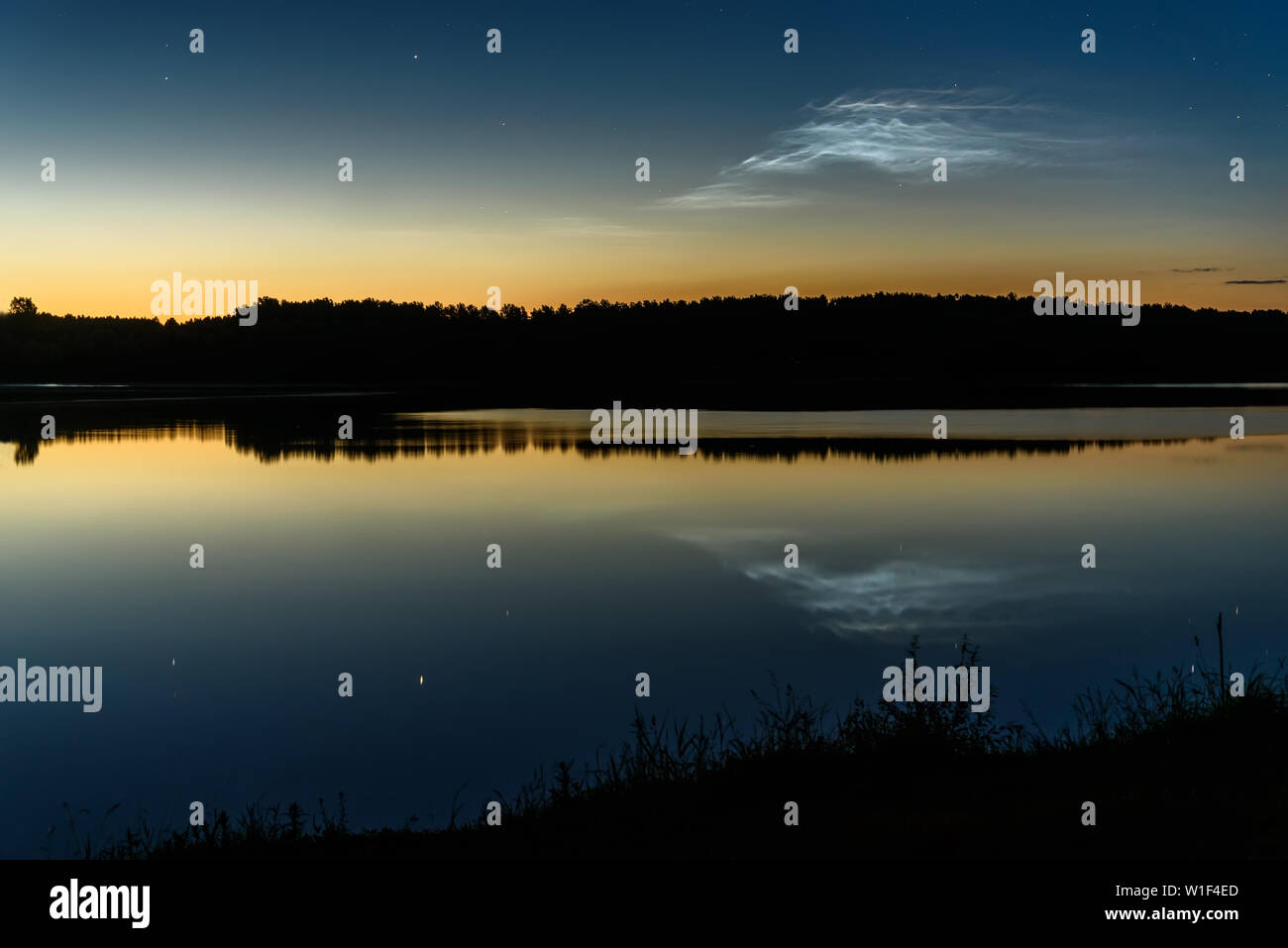 Amazing night landscape with luminous silvery clouds and stars in the ...