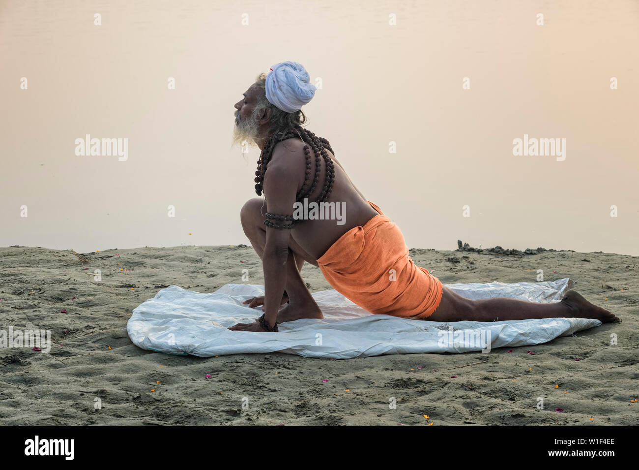 Rome Baba Sadhu practising yoga at sunrise on Ganges riverbank, For Editorial Use Only ...