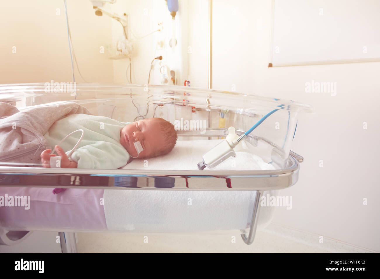 Little premature born child in intensive care unit in hospital sleeping ...