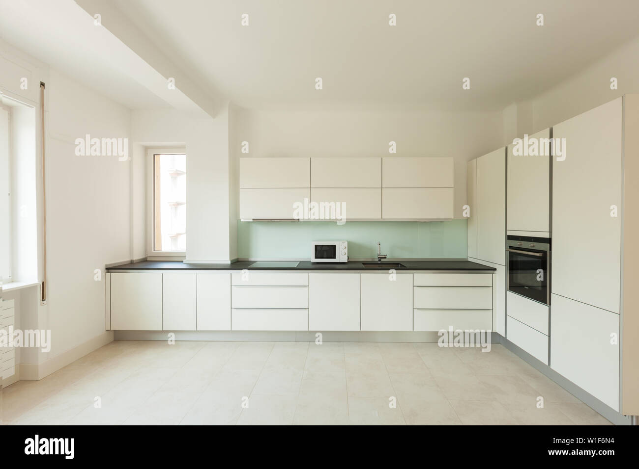 Wide white kitchen in a modern apartment Stock Photo - Alamy