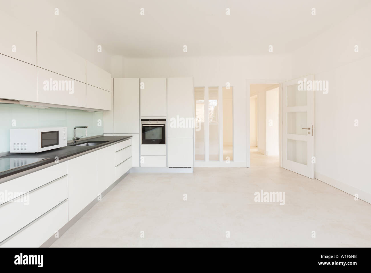 Wide white kitchen in a modern apartment Stock Photo - Alamy