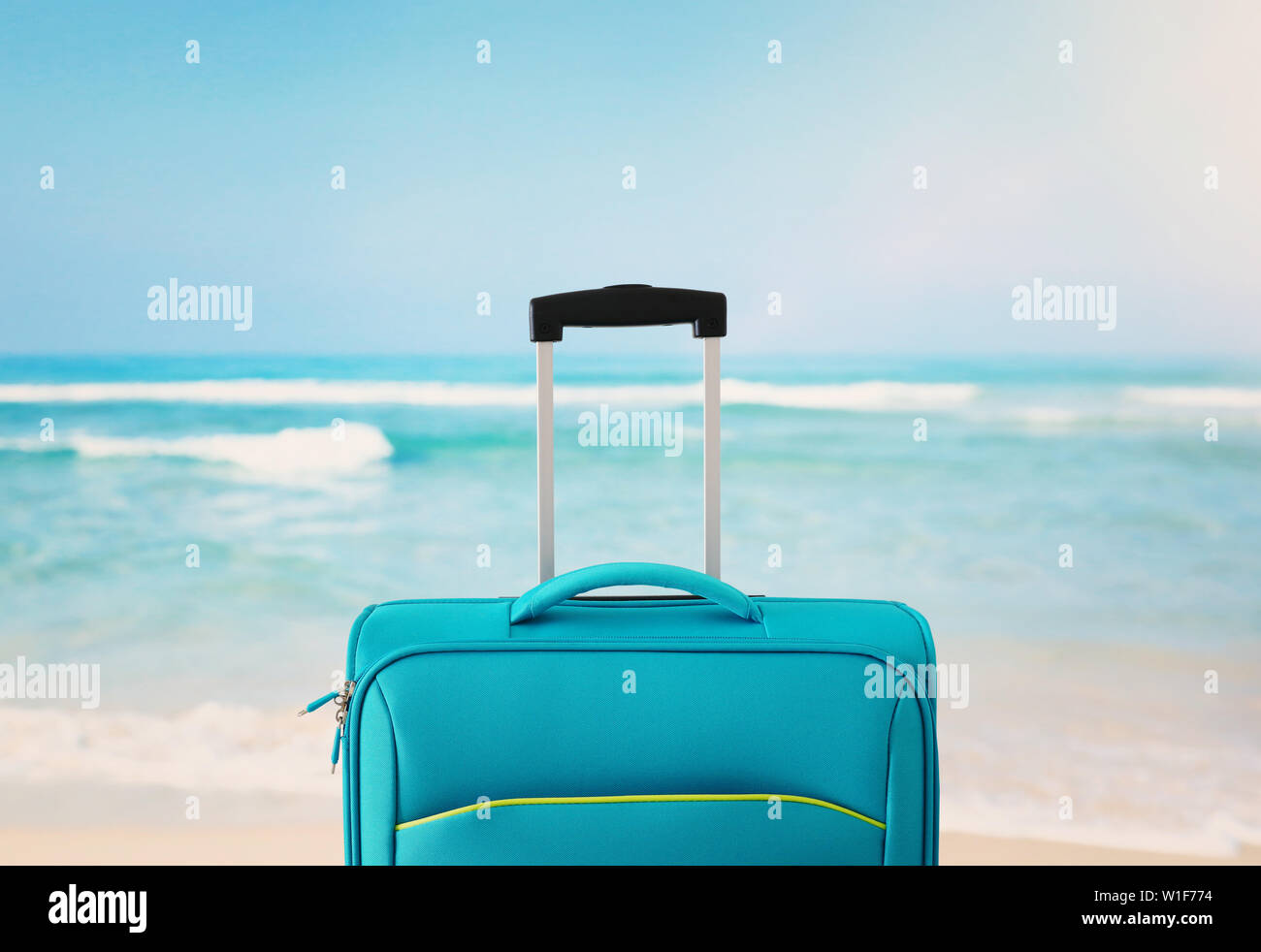 holidays. travel concept. blue suitcase infront of tropical background ...