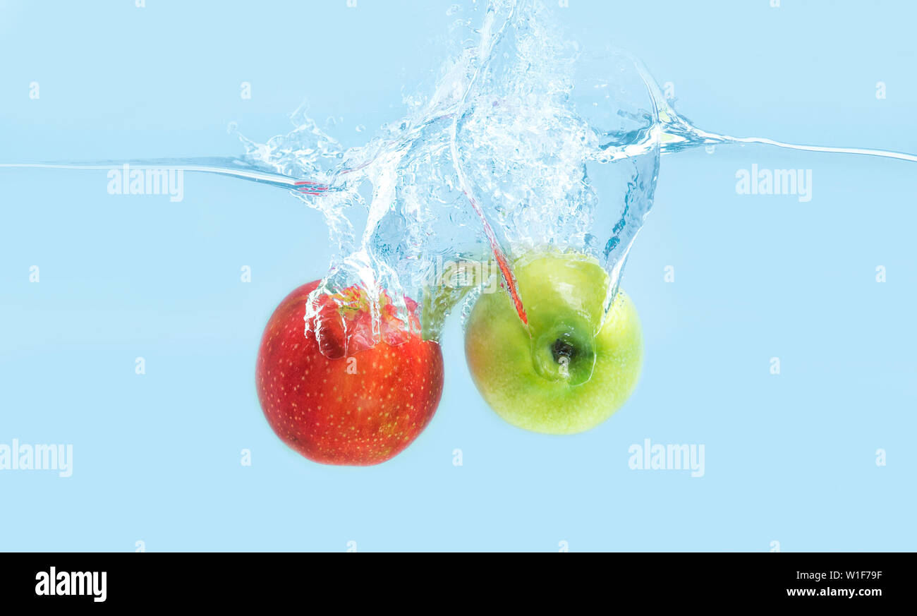 Red and green apples falling into water Stock Photo - Alamy