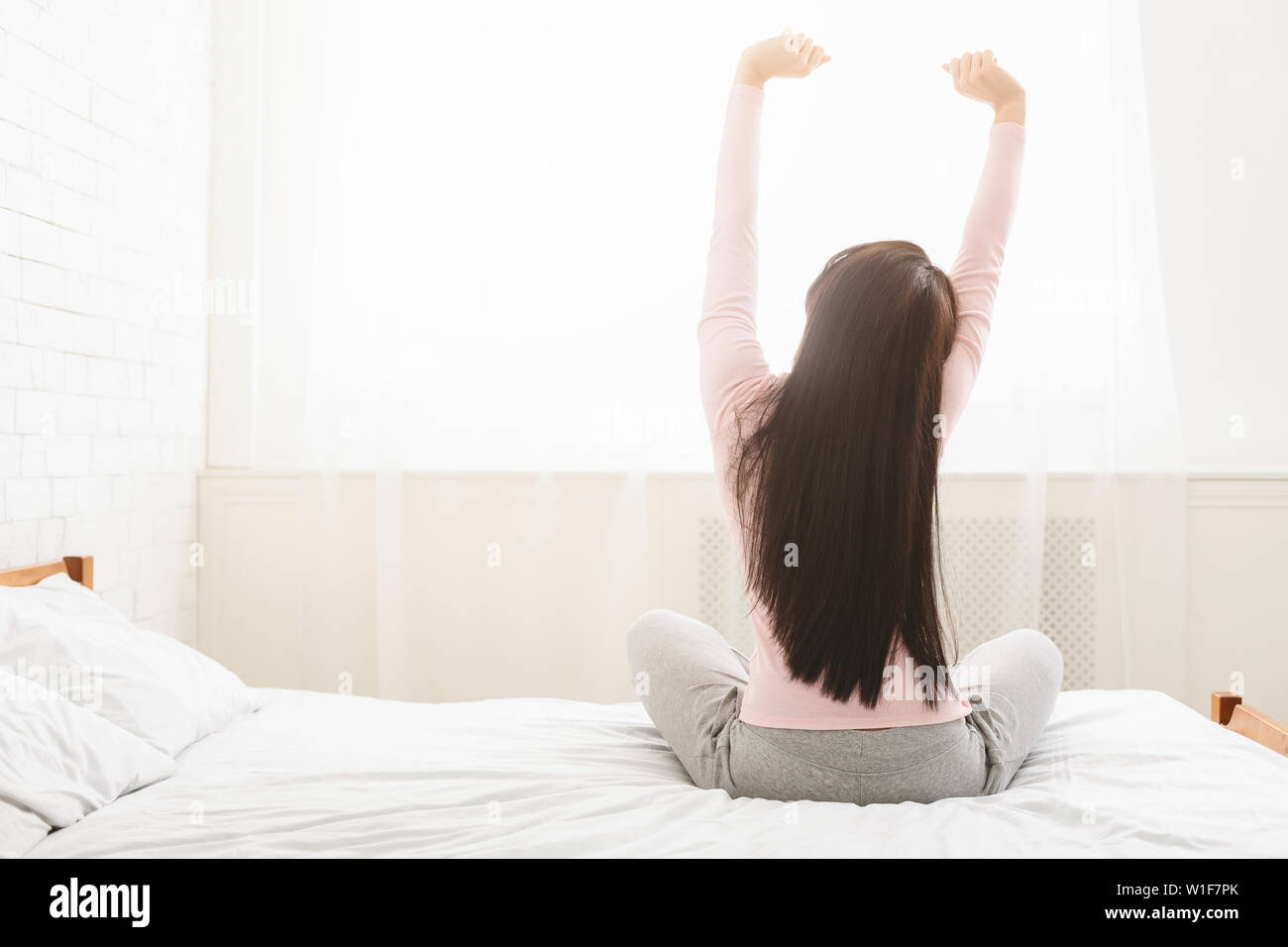 Young woman enjoying happy morning, stretching in bed Stock Photo - Alamy