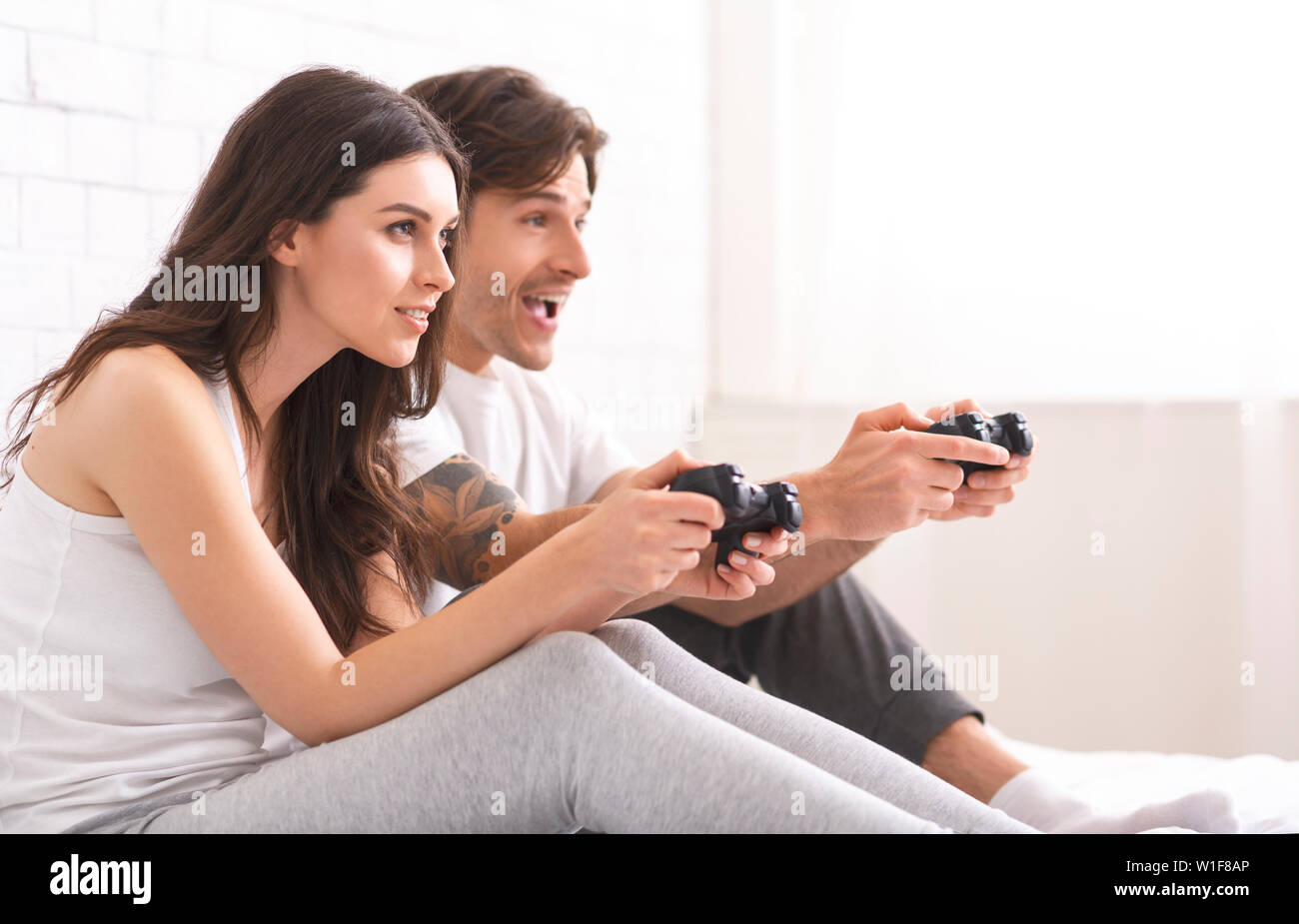 Concentrated man and woman competing in video game Stock Photo - Alamy