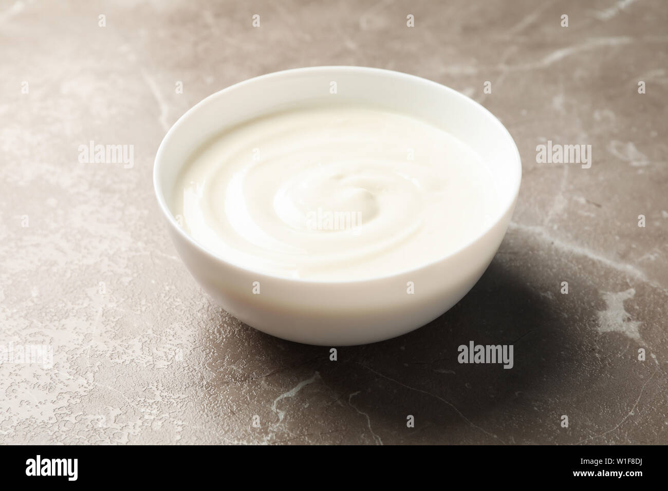 Bowl of sour cream yogurt on grey background Stock Photo - Alamy