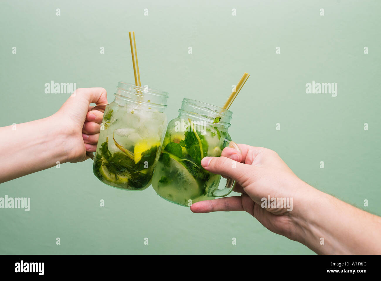 Man and woman are holding cocktails. Friends celebrate, say a greeting ...