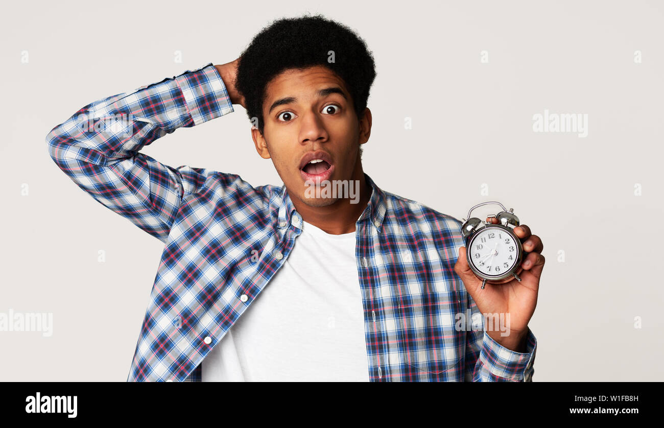 Shocked Afro Guy Holding Alarm Clock on White Background Stock Photo ...