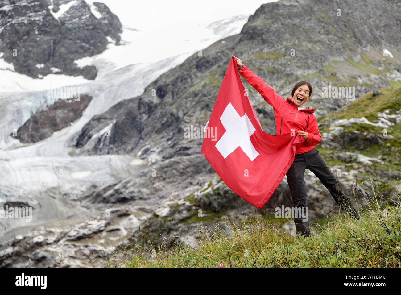 Switzerland hiker hiking cheering showing Swiss flag jumping in front ...