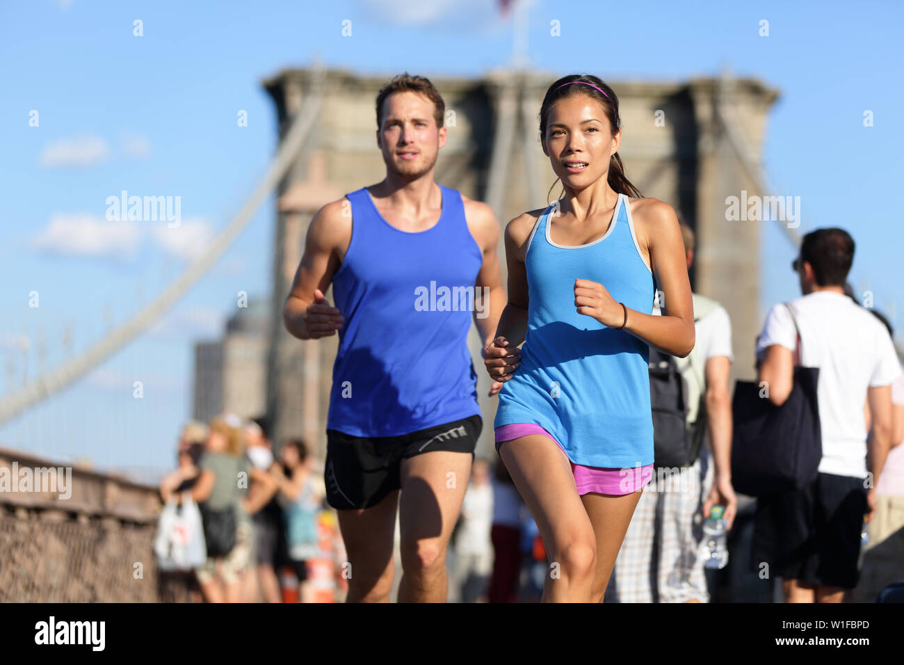 City running couple jogging outside. Runners training outdoors working ...