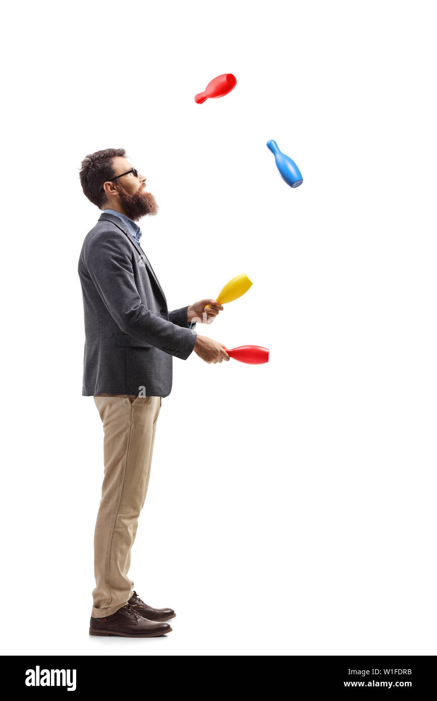 Full length profile shot of a bearded man juggling with clubs isolated ...