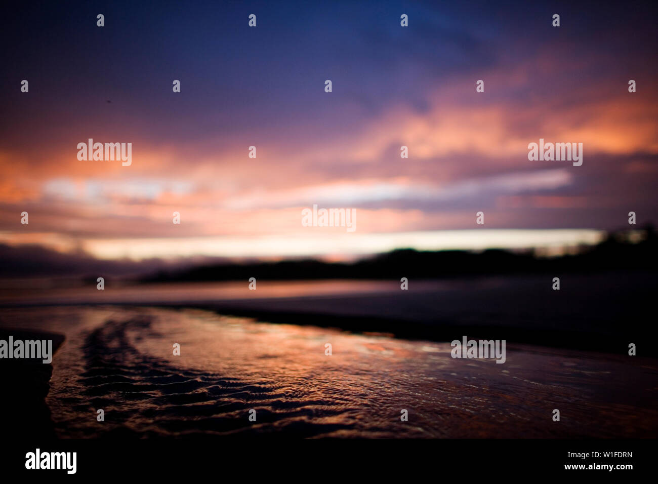 Waves washing ashore on a sandy beach Stock Photo - Alamy