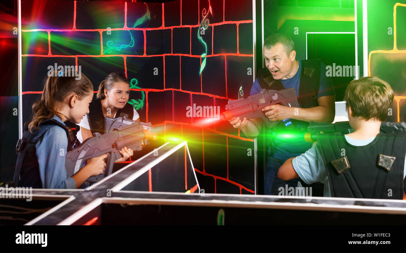 Group of happy kids and adults with laser guns having fun on lasertag ...