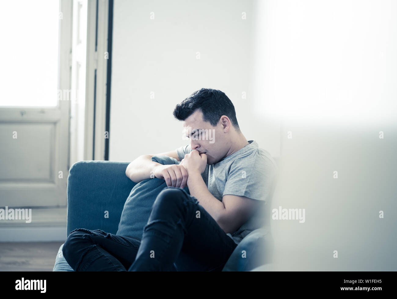 Portrait of young man felling depressed and desperate crying alone in ...