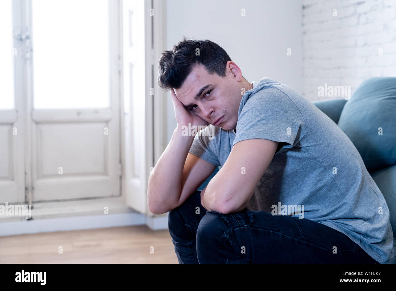 Portrait of young man felling depressed and desperate crying alone in ...