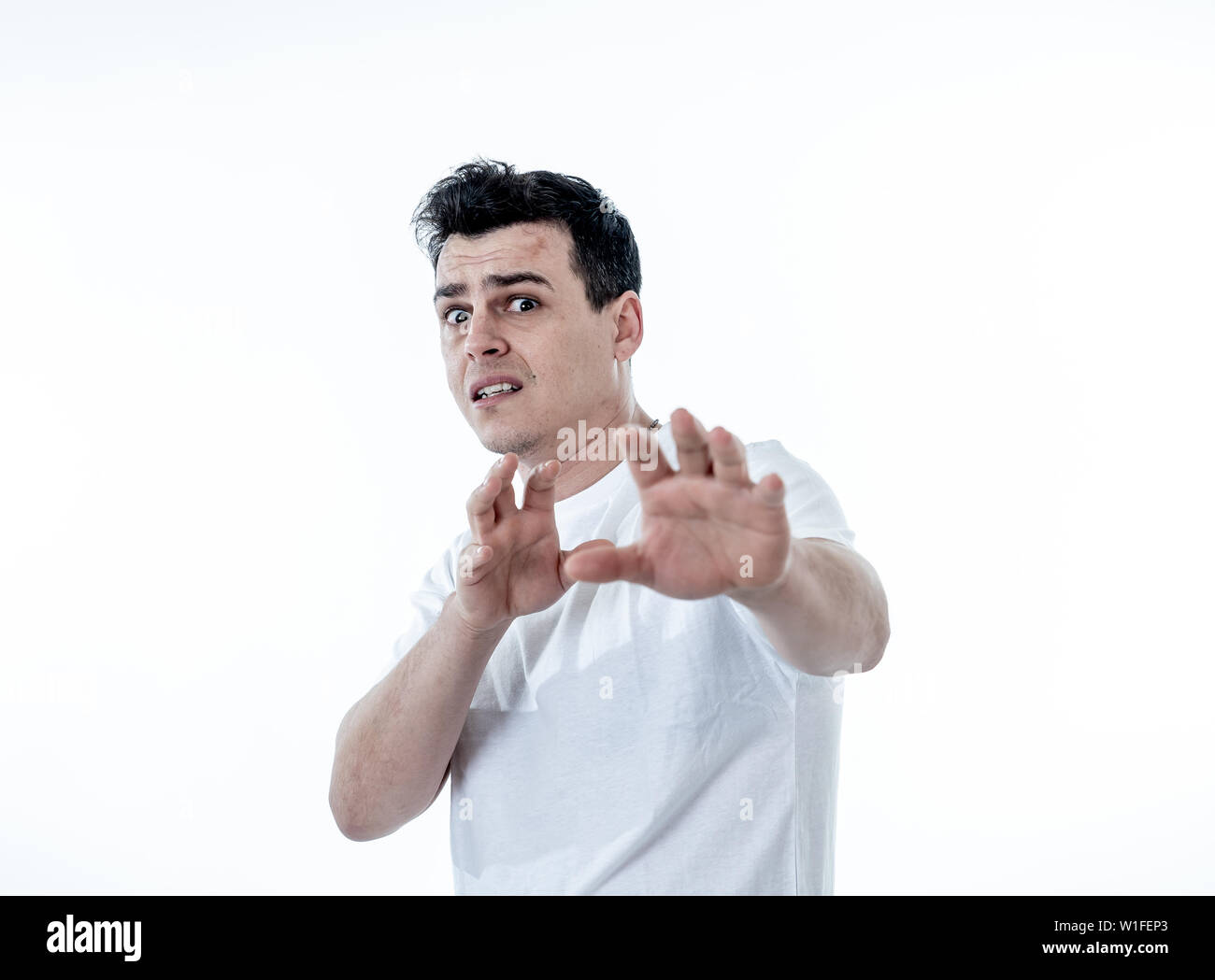 Portrait of young man in shock with a scared face expression making ...