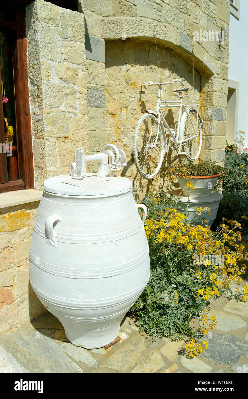 Bicycle painted white and a sewing machine on top of an urn painted ...