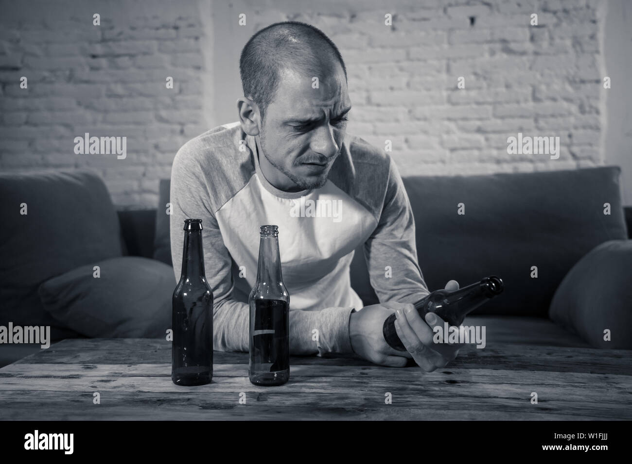 Young sad drunk men drinking beer and alcohol feeling wasted, lonely ...