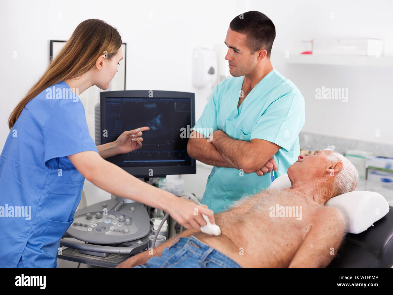 Two positive smiling confident sonographers working together examining ...