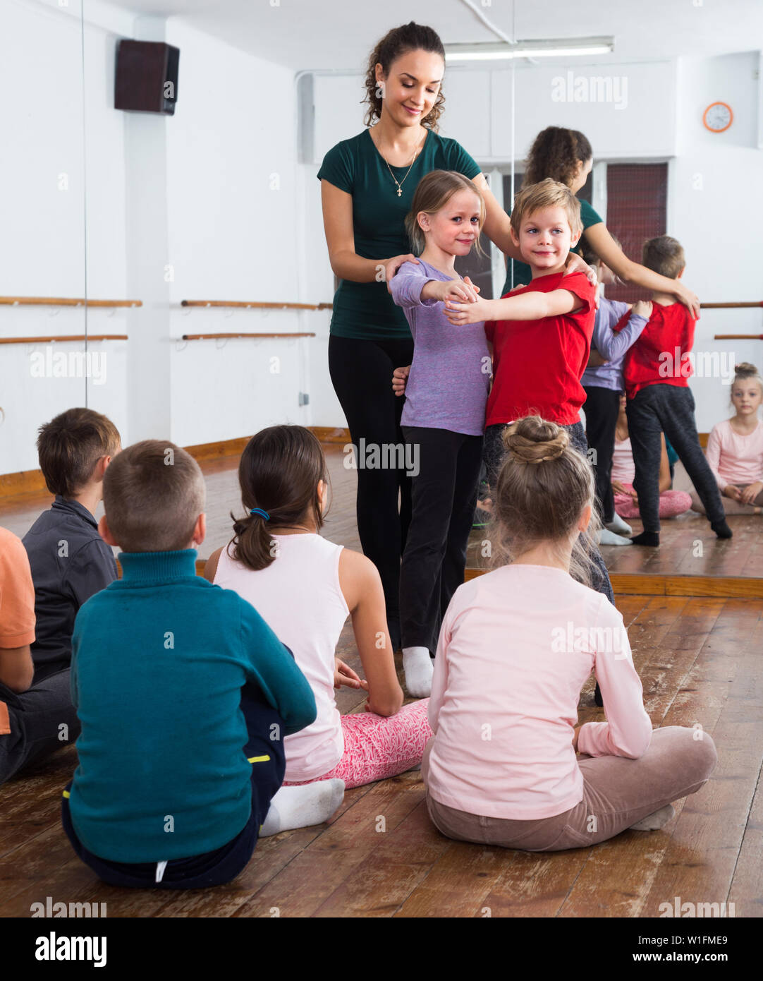 Group of positive children dancing elementary tango in dance studio ...
