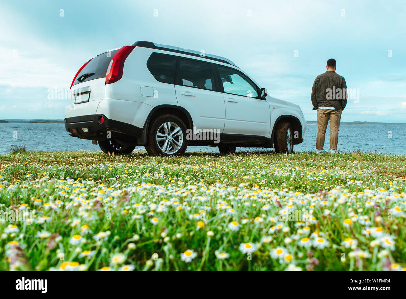 man standing near car at seaside. road trip concept. summer vacation ...