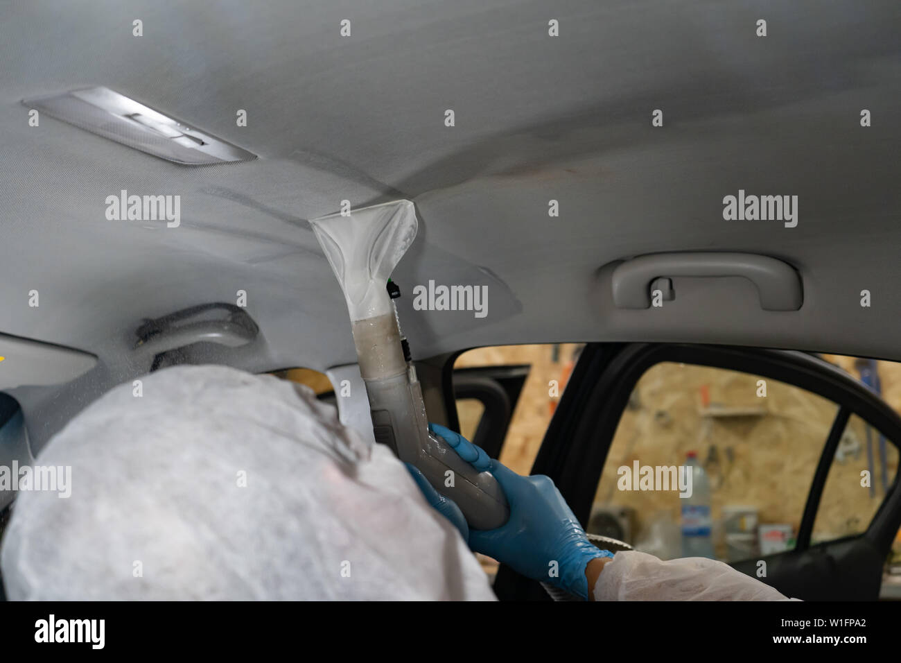 Dry cleaning salon cars. Male worker using vacuum cleaner in car Stock ...