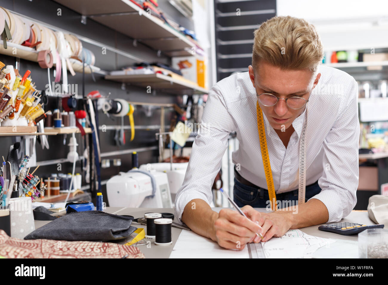 Professional male dressmaker at work – creating pattern at his ...
