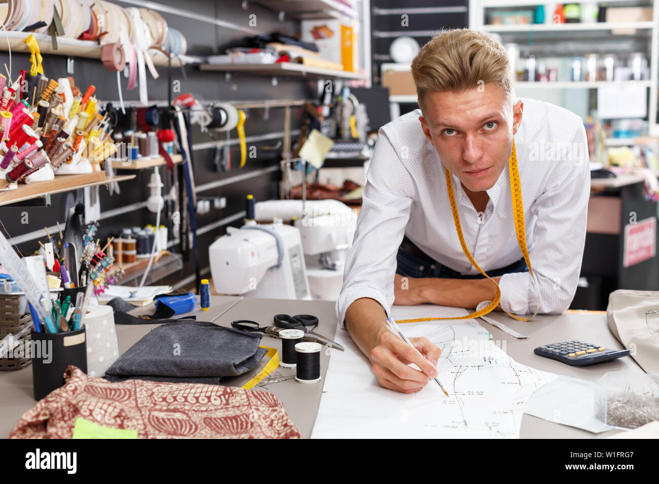 Professional male dressmaker at work – creating pattern at his ...